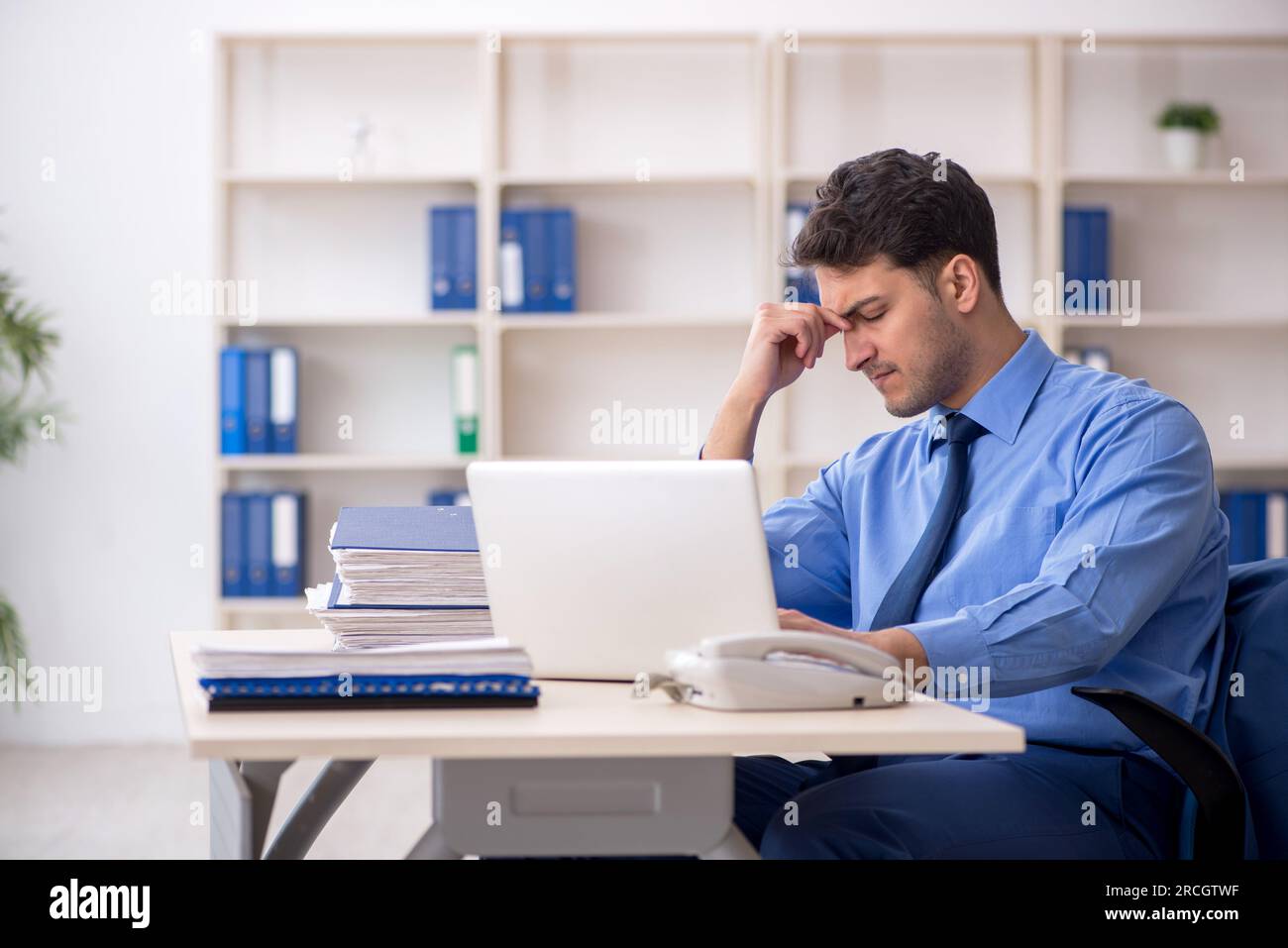 Young employee working at workplace Stock Photo - Alamy