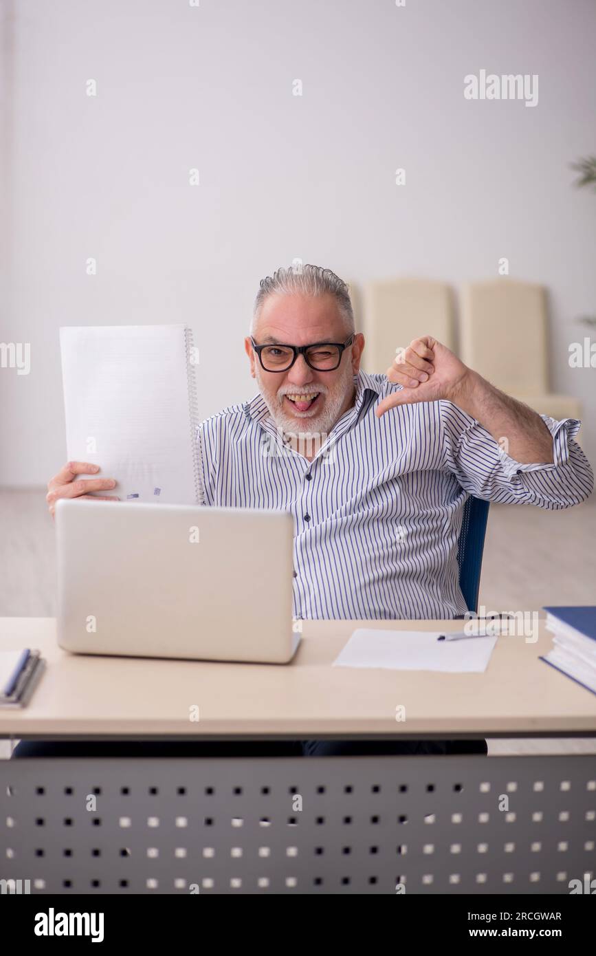 Old employee working at workplace Stock Photo - Alamy