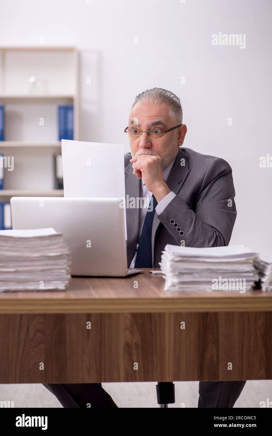 Old employee and too much work at workplace Stock Photo - Alamy