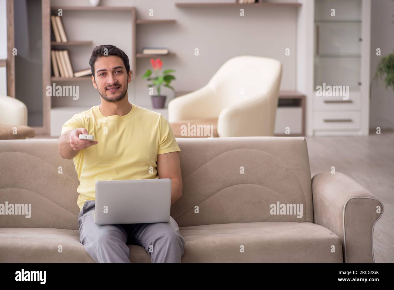 Young male student watching tv at home Stock Photo - Alamy