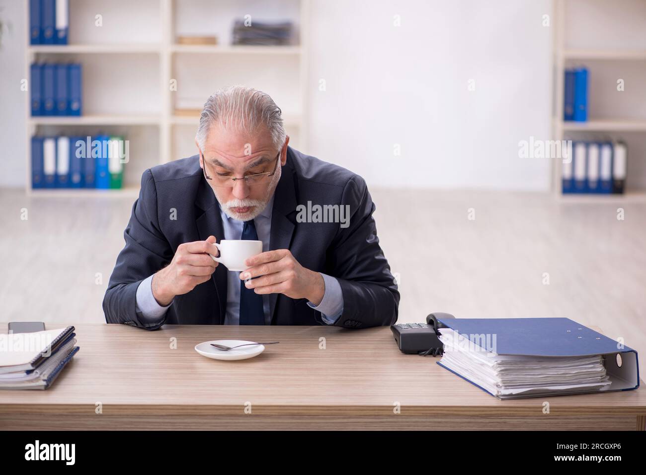 Old employee drinking tea at workplace Stock Photo - Alamy
