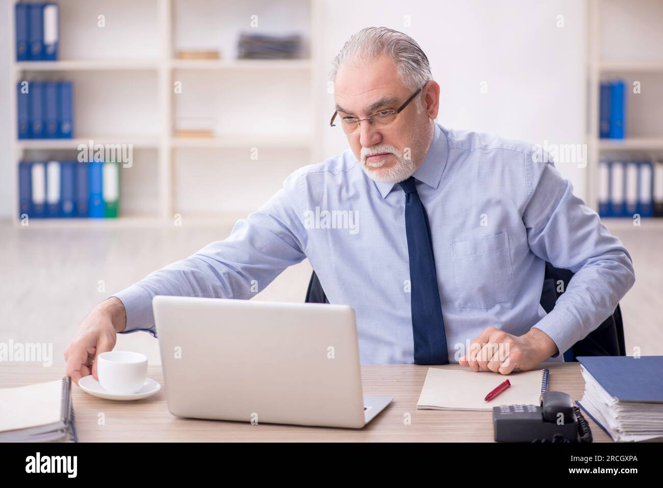 Old employee drinking tea at workplace Stock Photo - Alamy