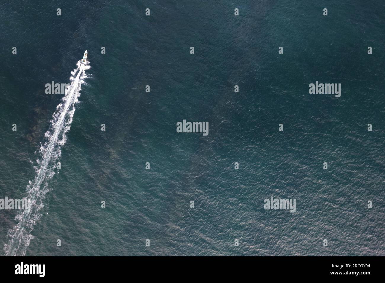 Small boat on ocean blue water bay above top view Stock Photo - Alamy