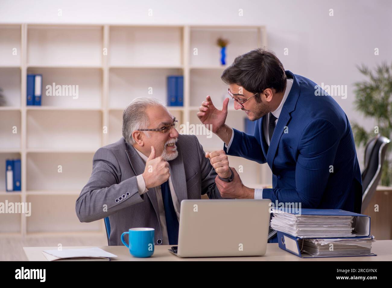 Old boss and young employee in the office Stock Photo - Alamy