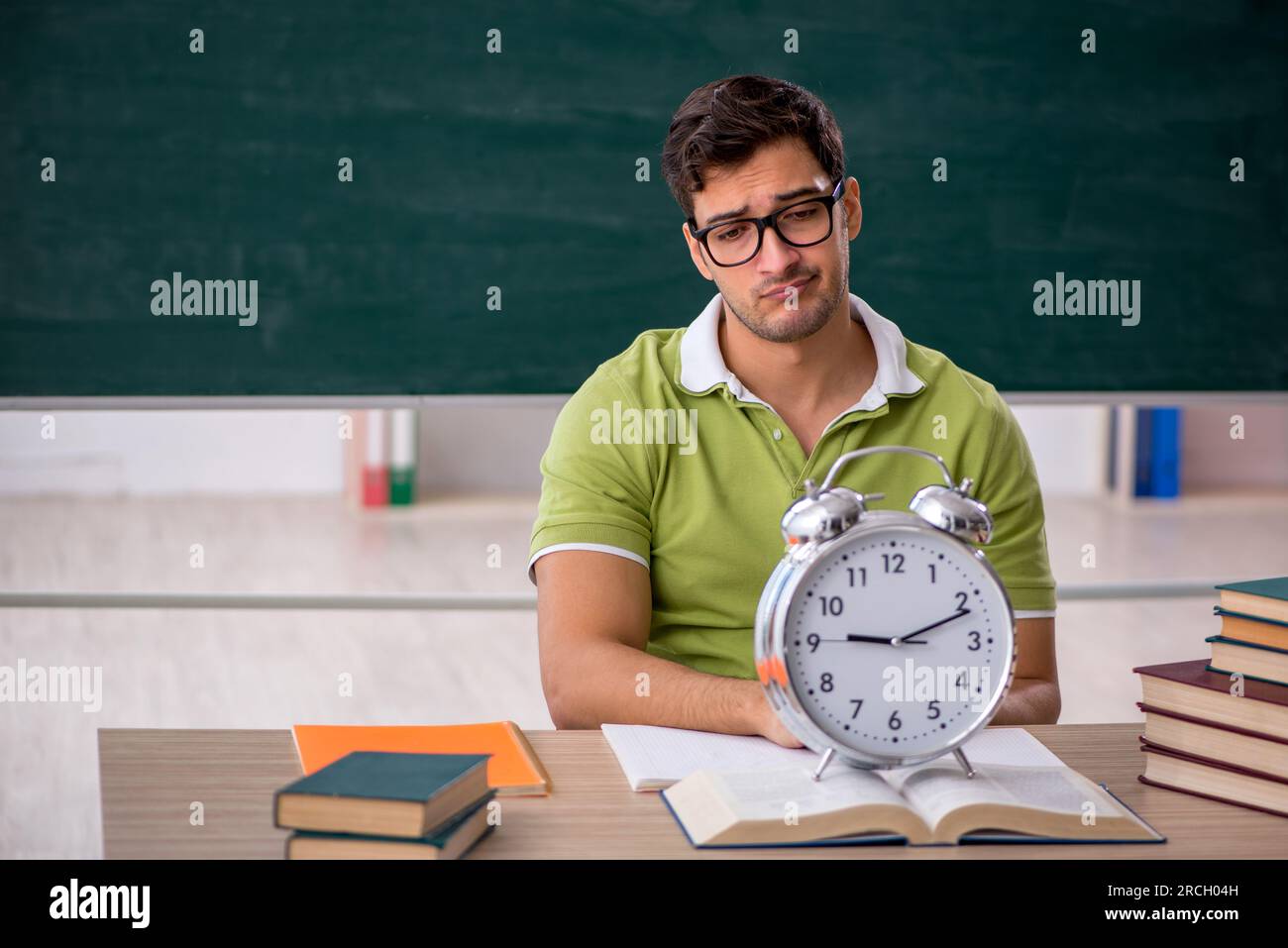 Young student in the classroom in time management concept Stock Photo ...