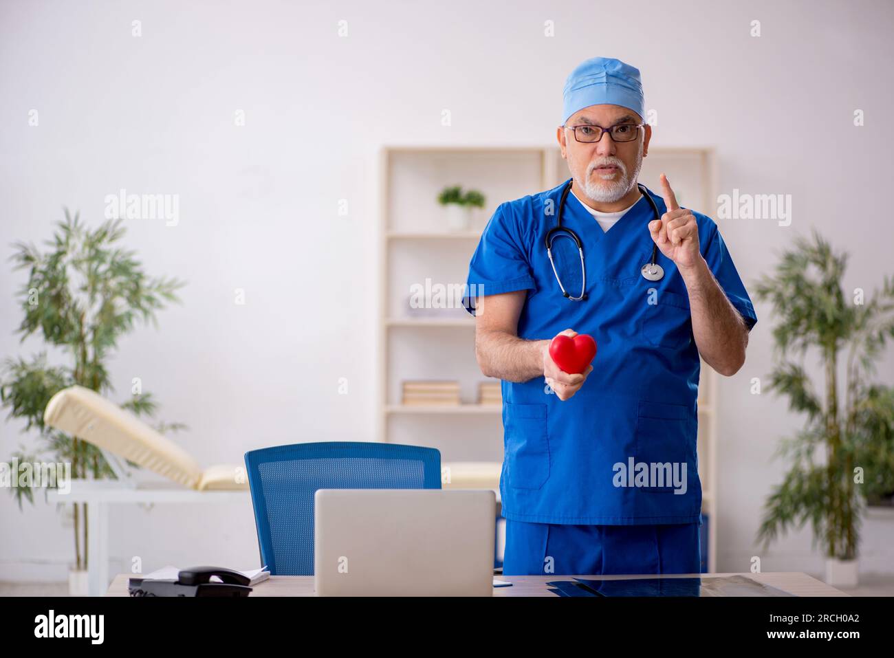 Old doctor cardiologist working in the clinic Stock Photo - Alamy