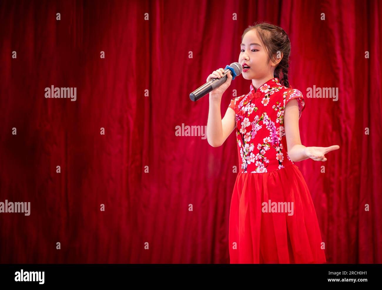 The Asian kid girl sing a song on stage at her school activity day ...