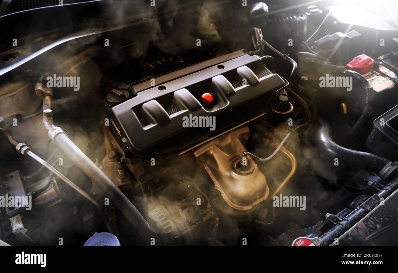Closeup of a broken car engine with smoke coming out of the engine ...