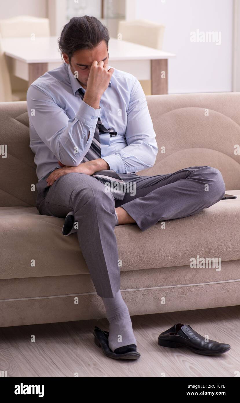 Tired businessman coming home after working day Stock Photo - Alamy