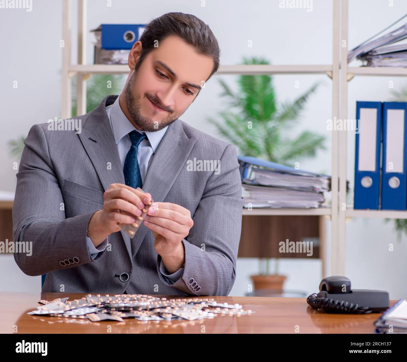 Male sick employee suffering at workplace Stock Photo - Alamy