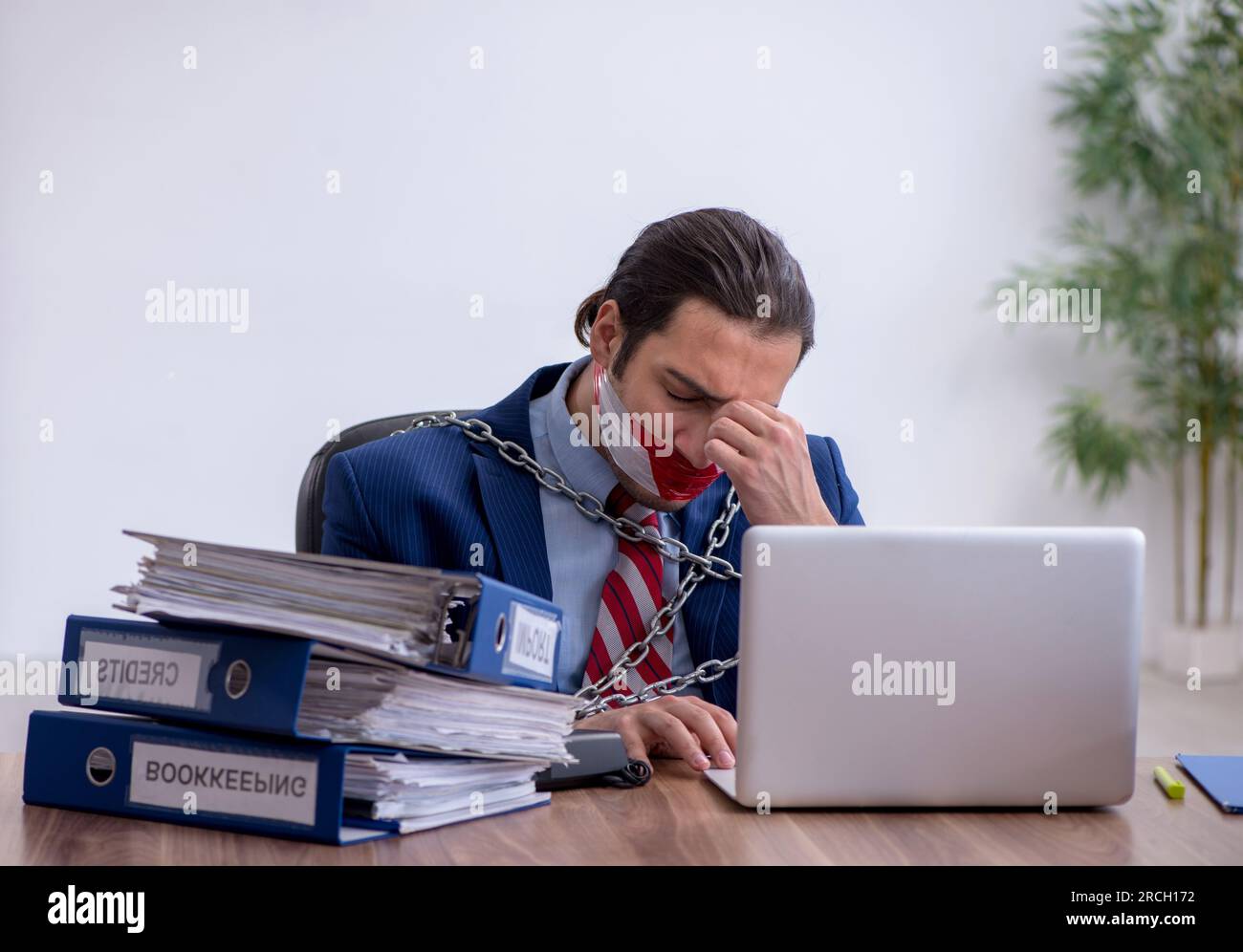 Chained employee unhappy with excessive work in the office Stock Photo ...