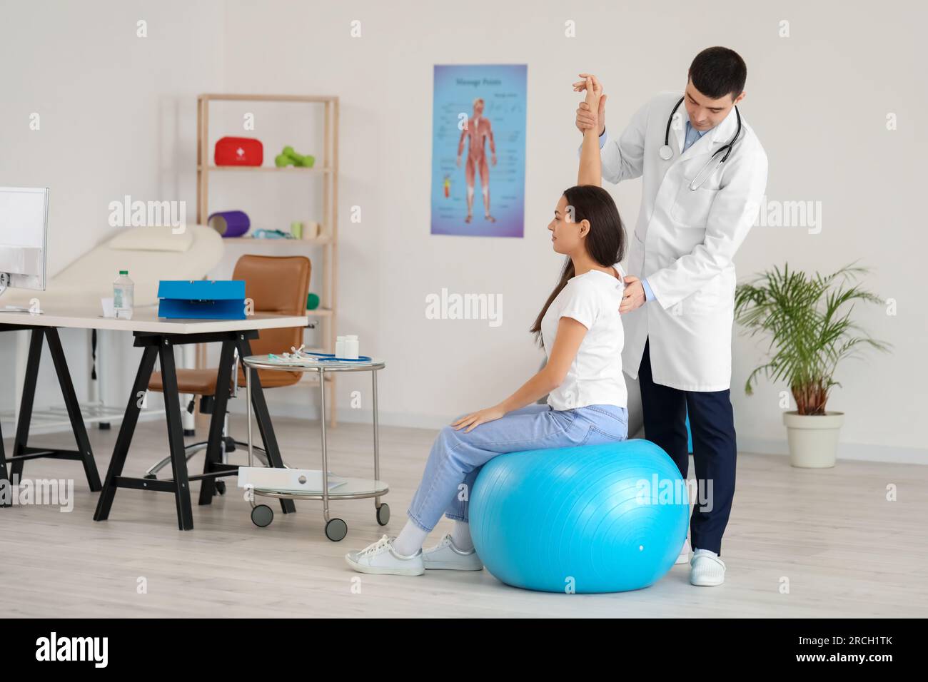 Male doctor checking posture of young woman in clinic Stock Photo - Alamy