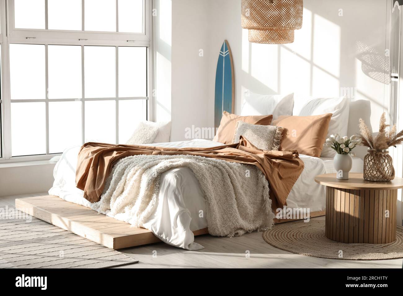 Interior of modern bedroom with surfboard and big bed Stock Photo - Alamy