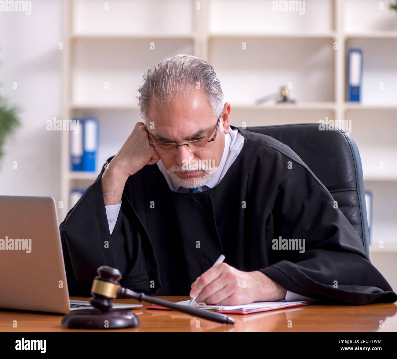 Old male judge working in the courthouse Stock Photo - Alamy