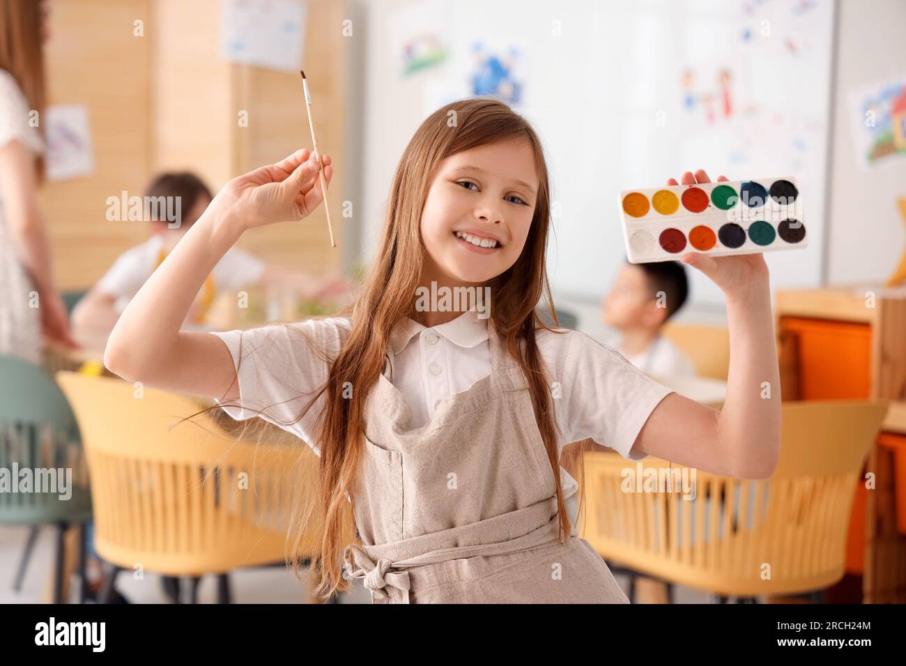 Little girl with paints in art class Stock Photo - Alamy