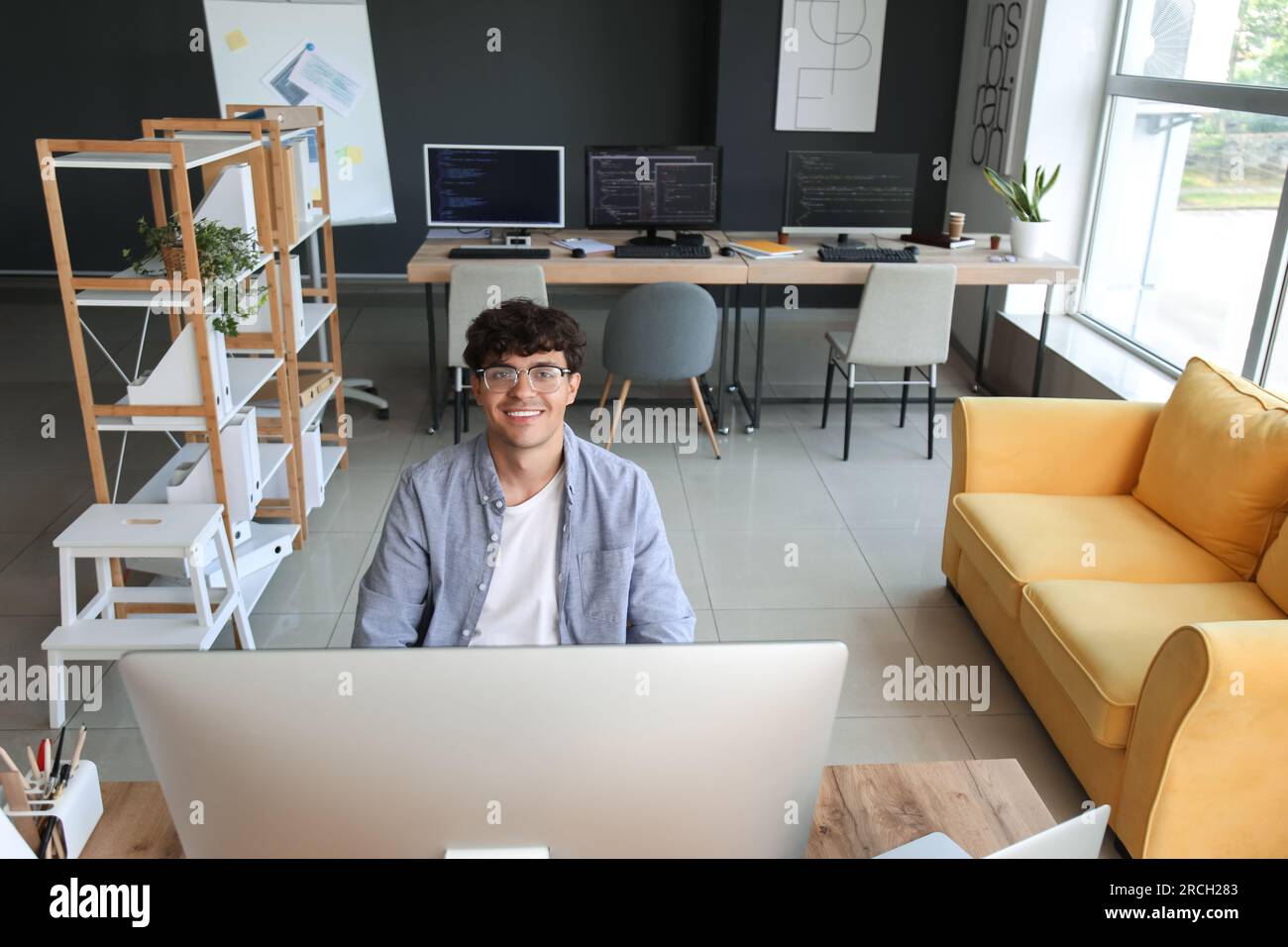 Male programmer working with computer at table in office Stock Photo ...