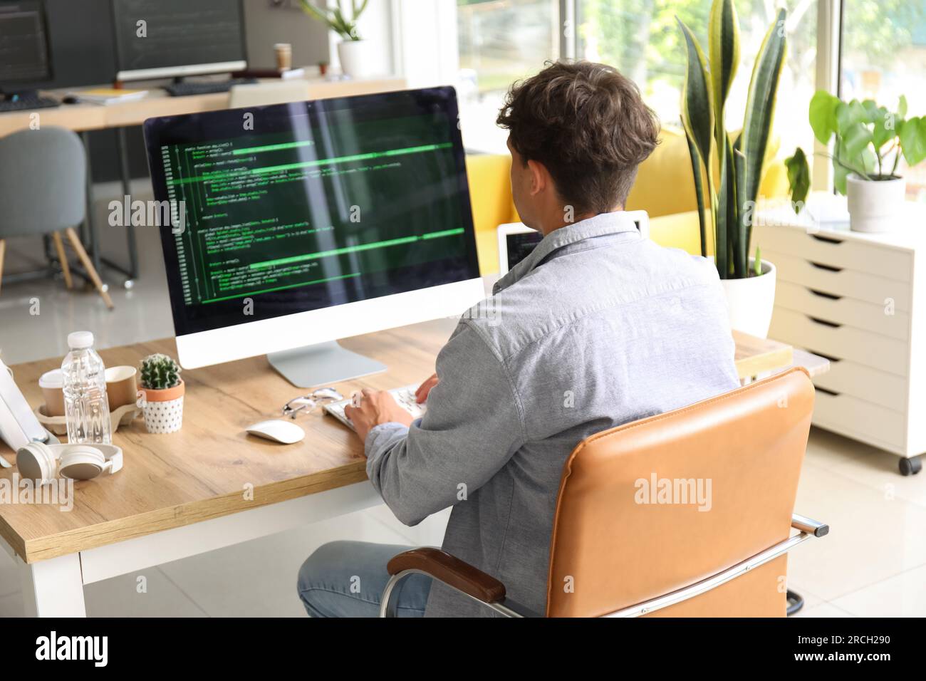Male programmer working with computer at table in office Stock Photo - Alamy