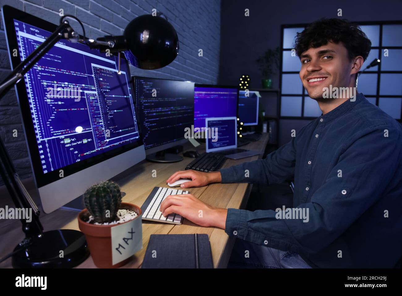 Male programmer working with computer in office at night Stock Photo ...
