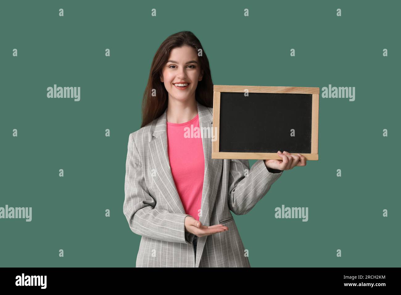 Female teacher with chalkboard on green background Stock Photo - Alamy