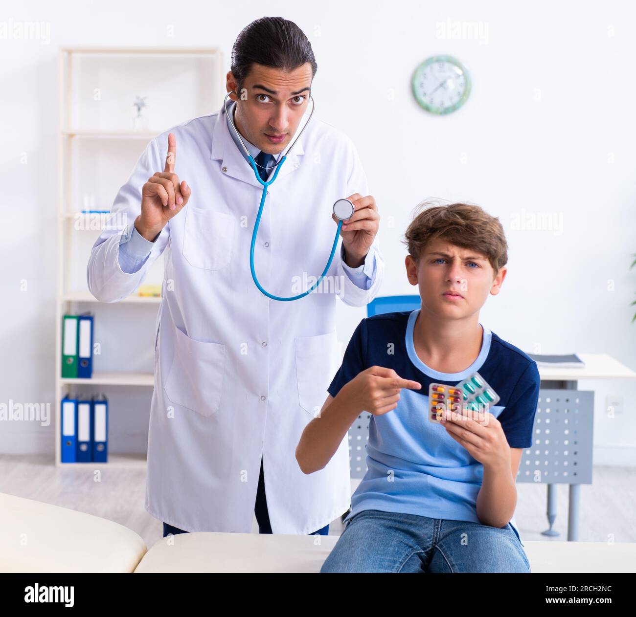 The young male doctor examining boy in the clinic Stock Photo - Alamy