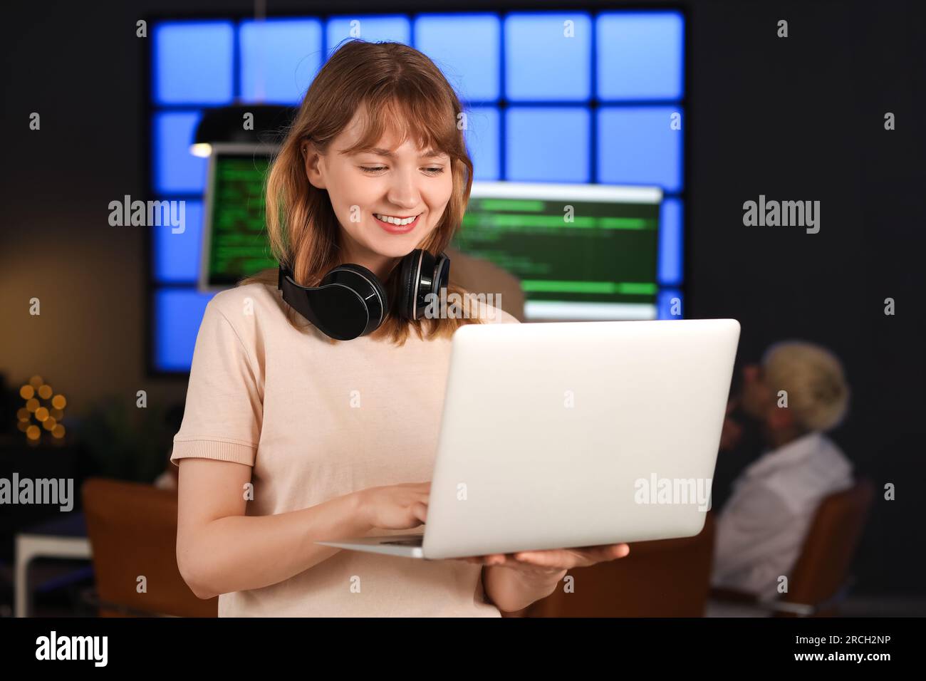 Female programmer working with laptop in office at night Stock Photo ...