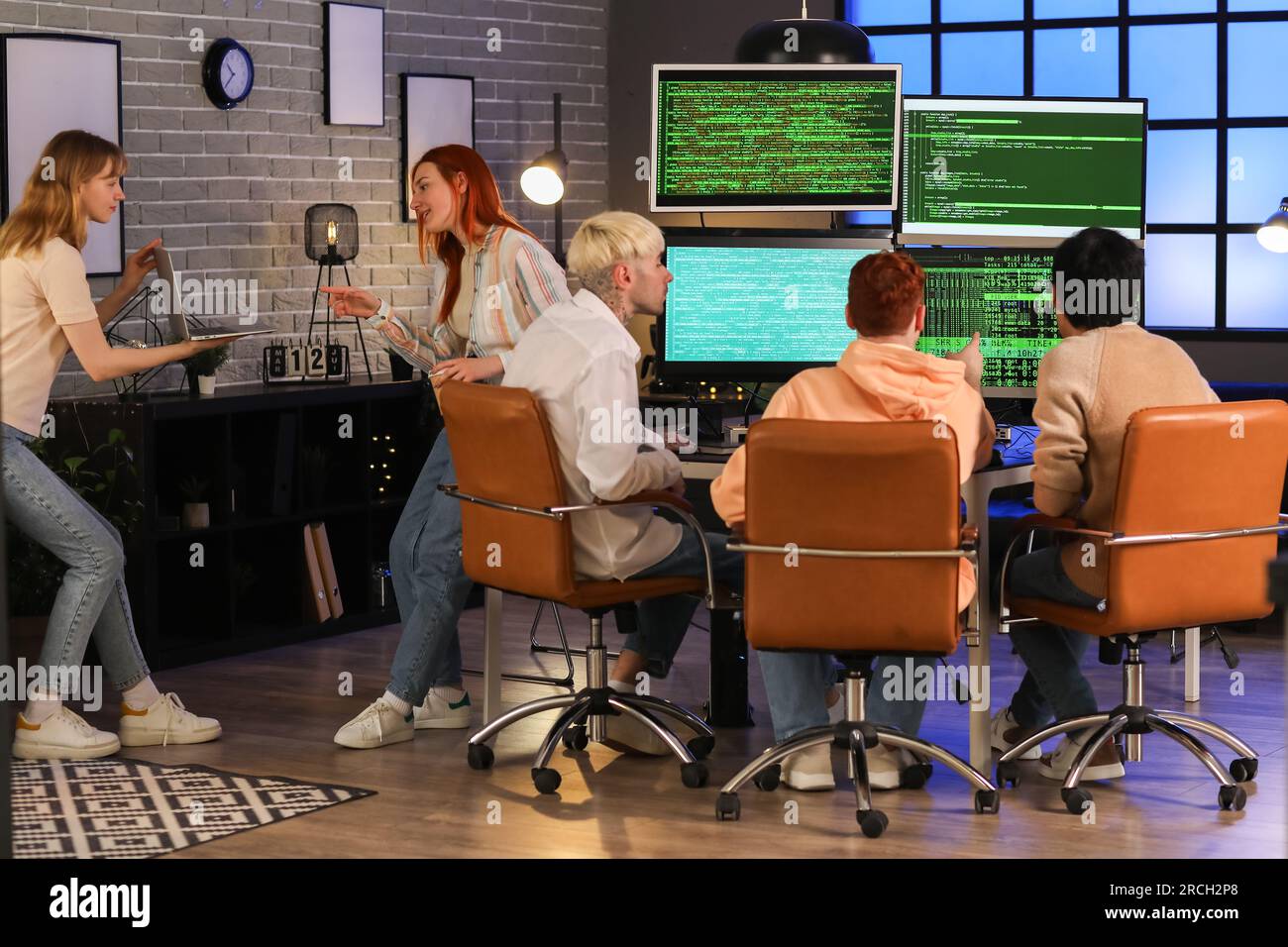 Team of young programmers working in office at night Stock Photo - Alamy