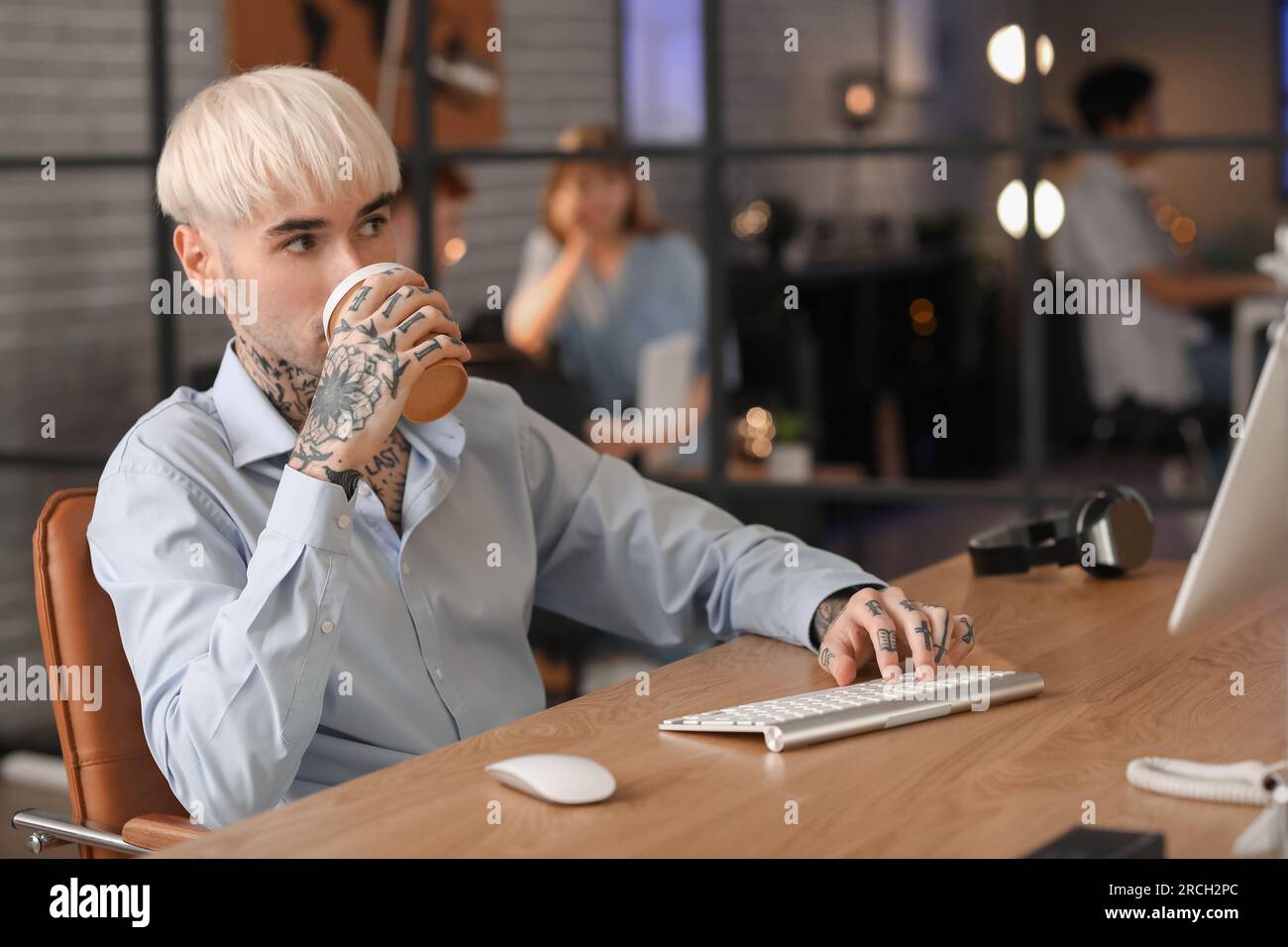 Male programmer drinking coffee in office at night Stock Photo - Alamy