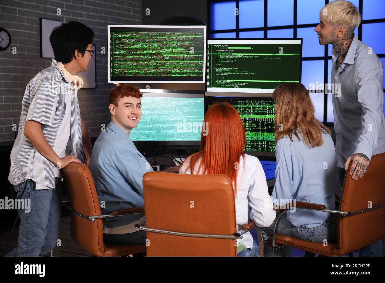 Team of young programmers working in office at night Stock Photo - Alamy