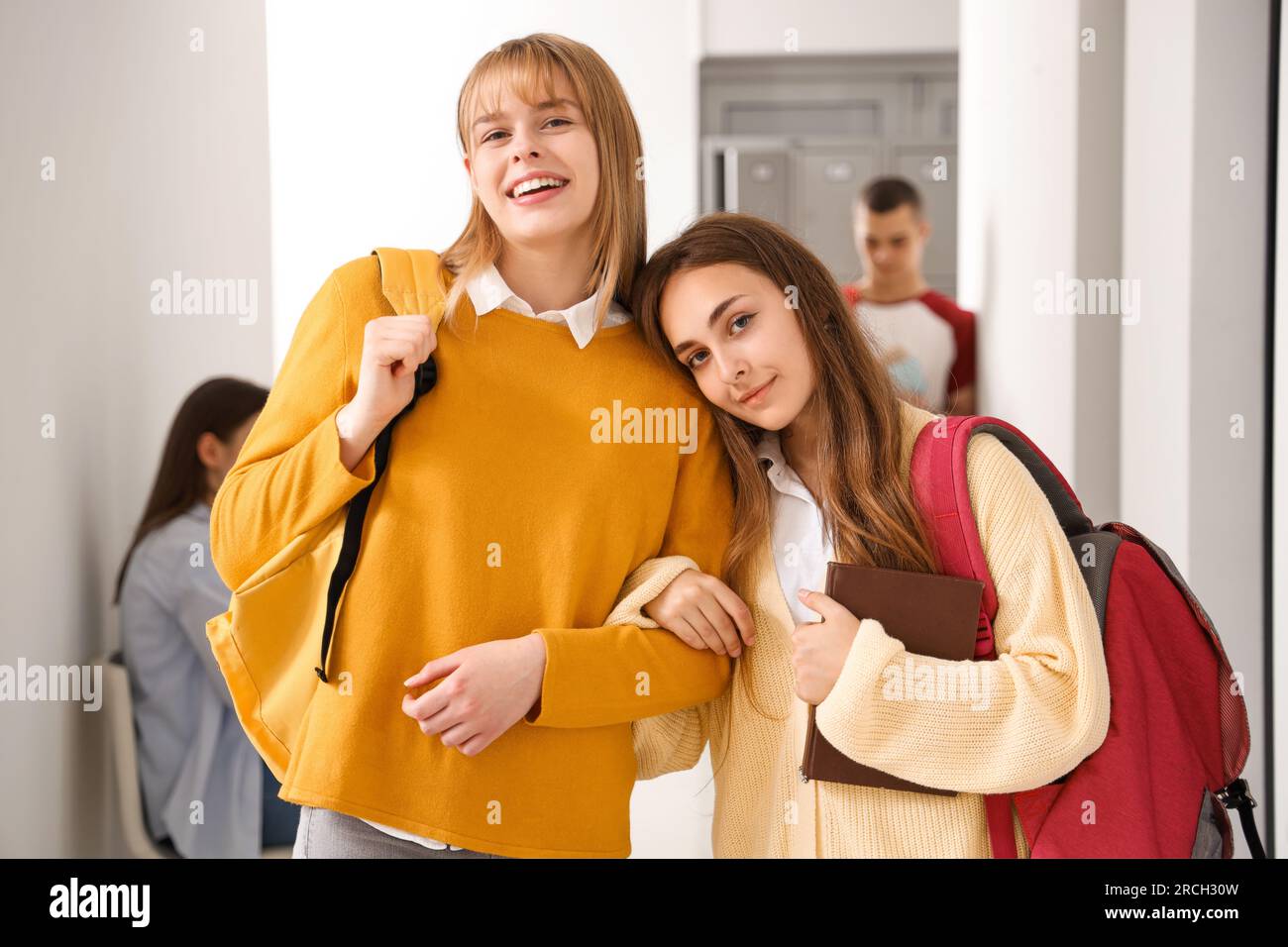 Teenage girls hugging at school Stock Photo - Alamy