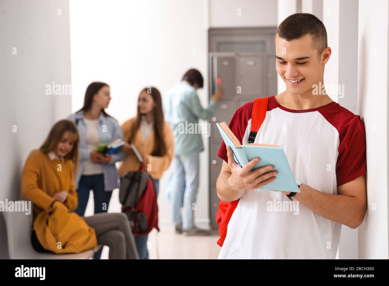 Teenage boy reading book at school Stock Photo - Alamy