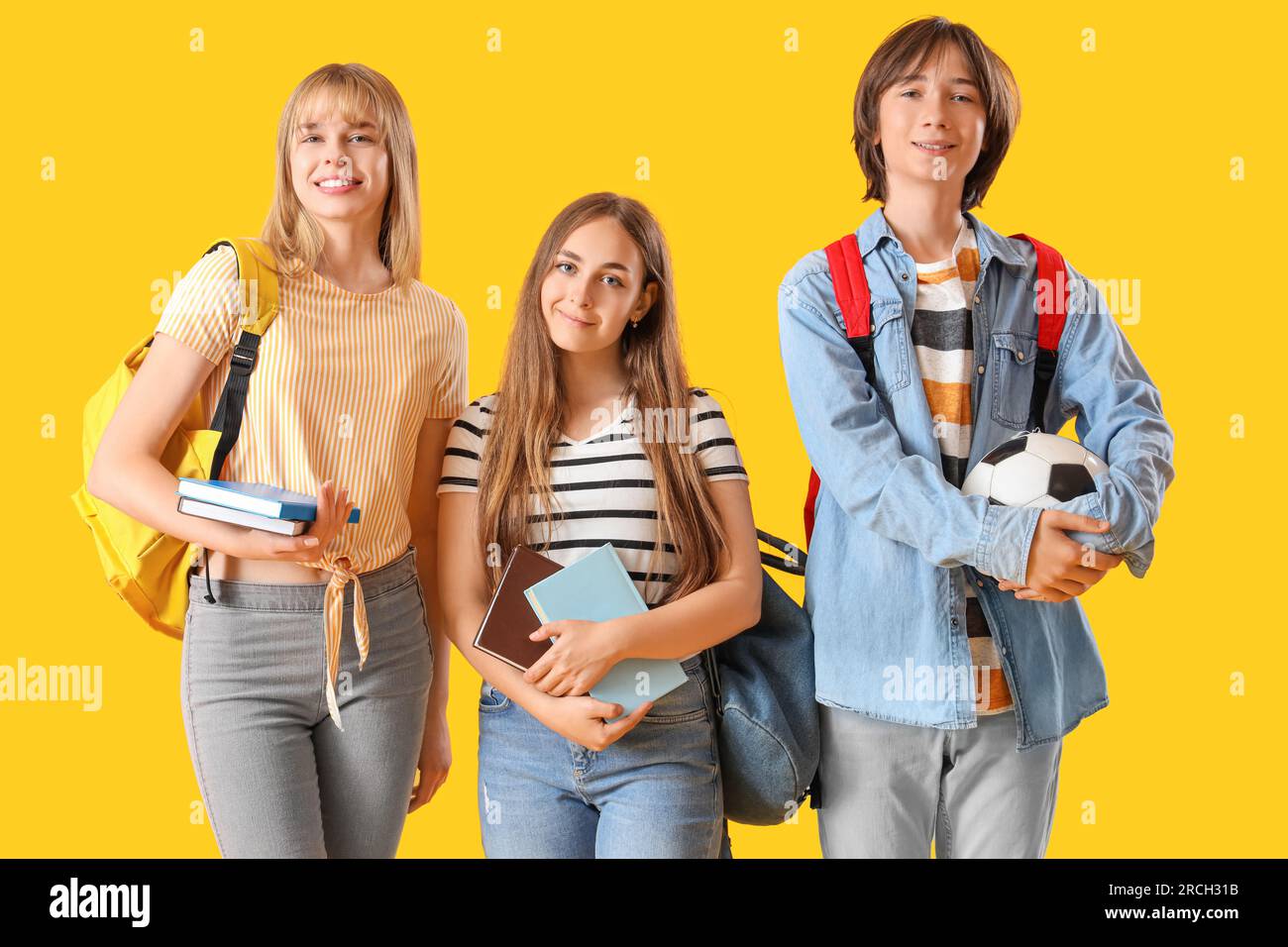 Teenage students on yellow background Stock Photo - Alamy