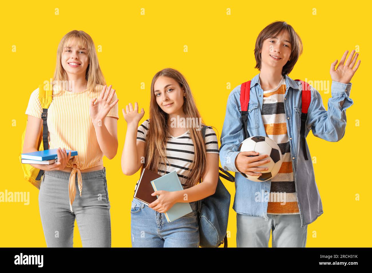 Teenage students waving hands on yellow background Stock Photo - Alamy