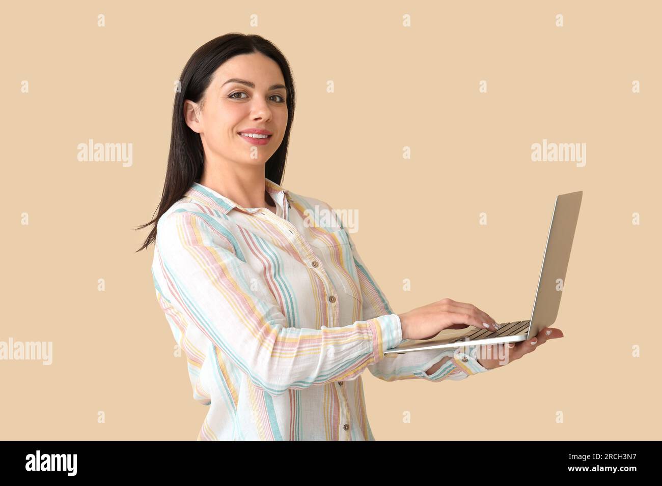 Female programmer working with laptop on beige background Stock Photo ...