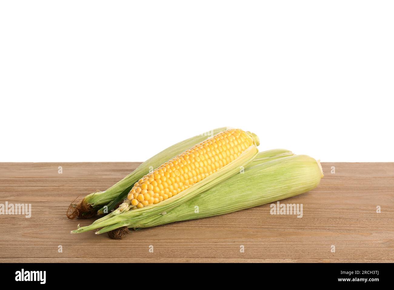 Fresh corn cobs on wooden table against white background Stock Photo ...