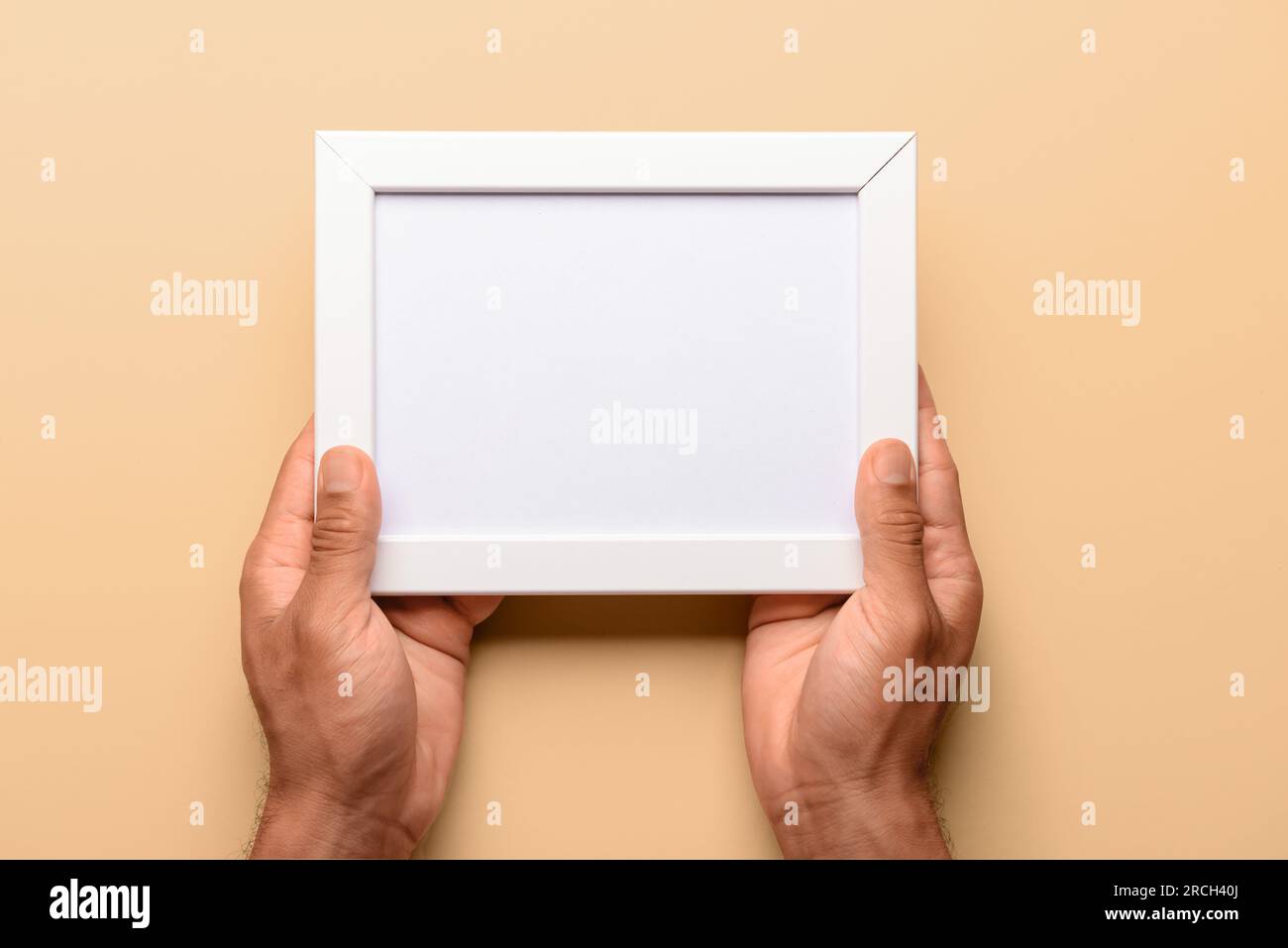 Man holding blank photo frame on beige background Stock Photo - Alamy