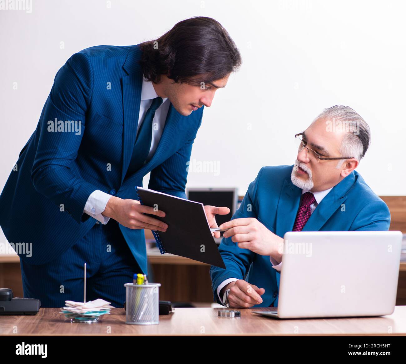 The young and old employees working together in the office Stock Photo ...