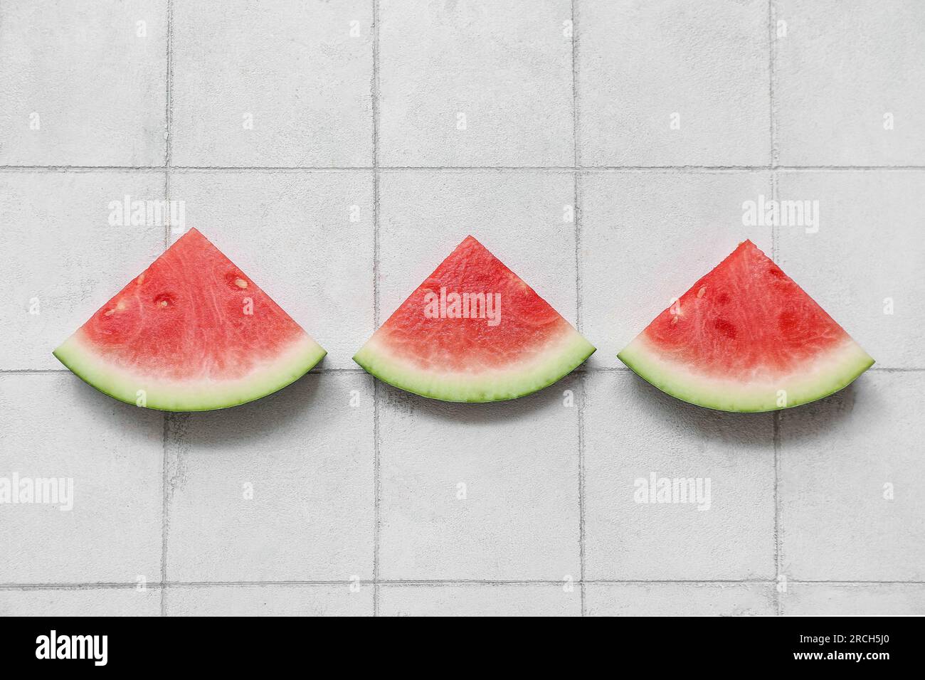 Pieces of fresh watermelon on white tile background Stock Photo - Alamy