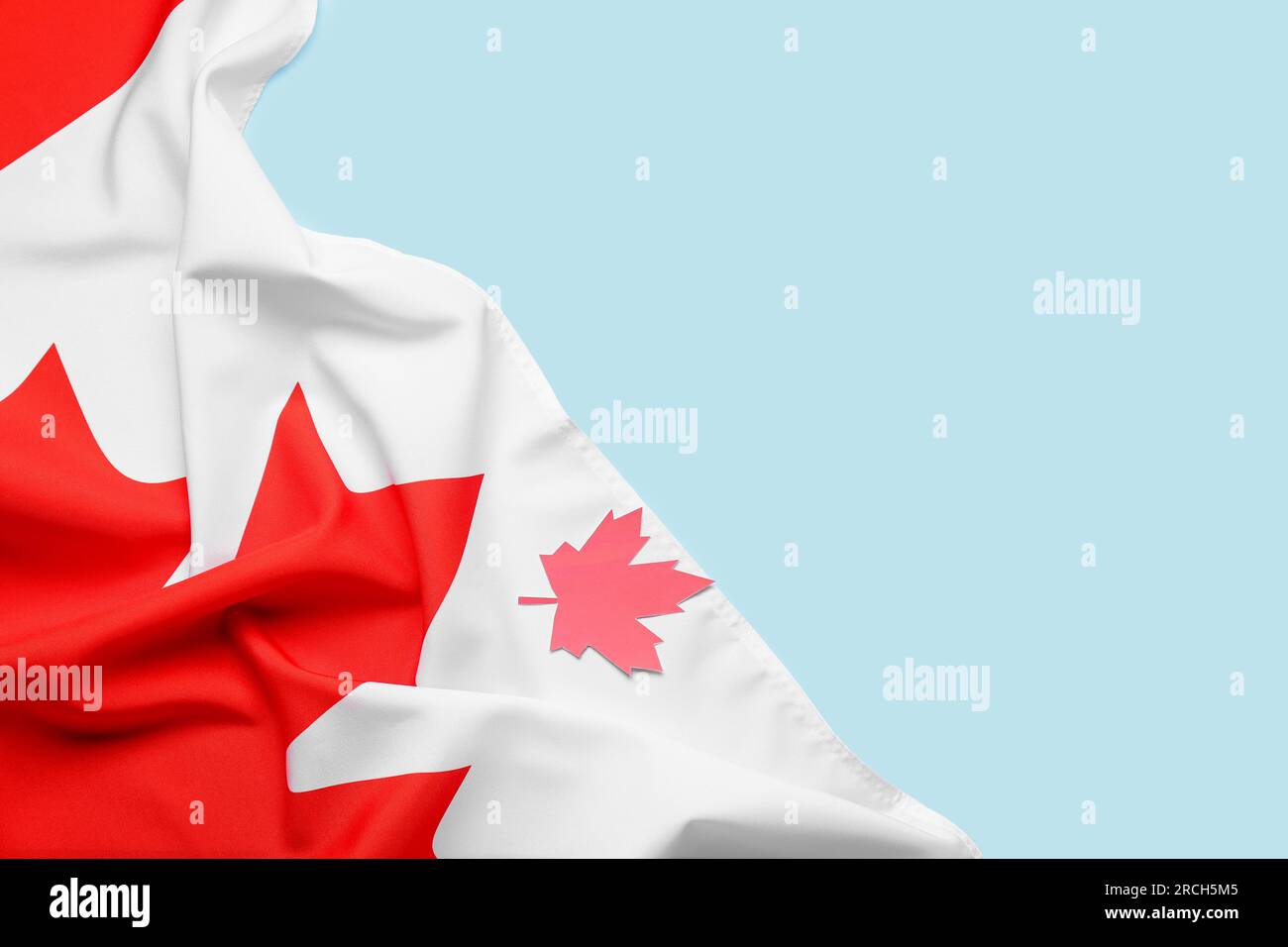 Flag of Canada with paper maple leaf on blue background Stock Photo - Alamy
