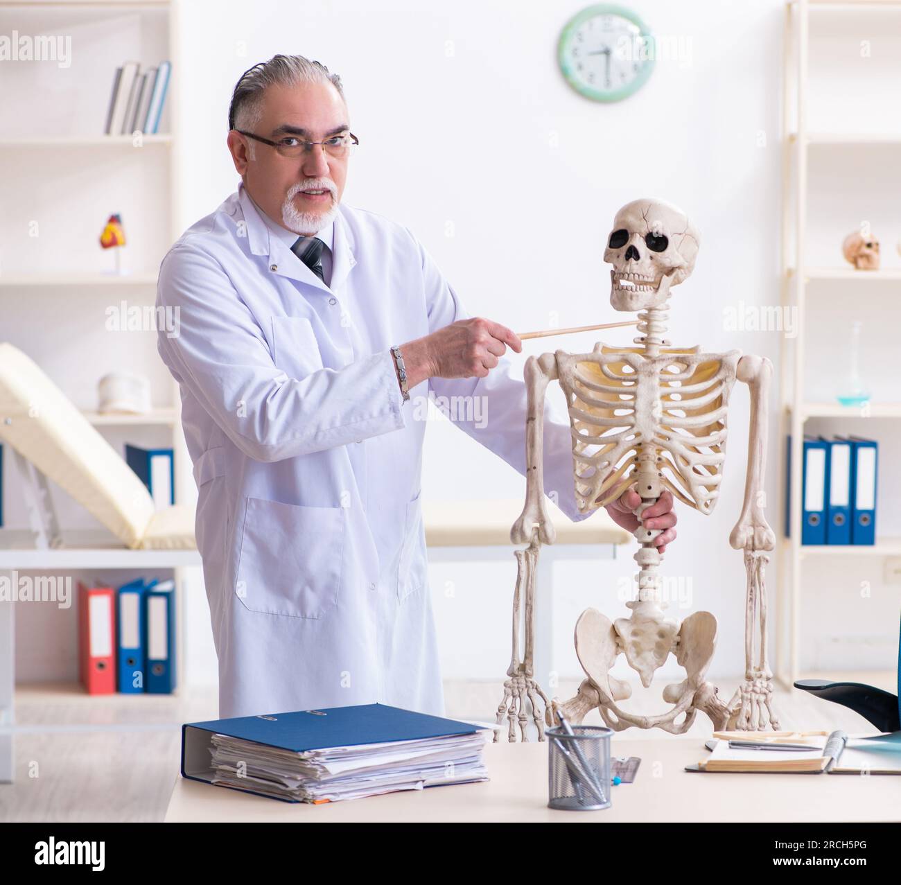 The aged male doctor with skeleton Stock Photo - Alamy