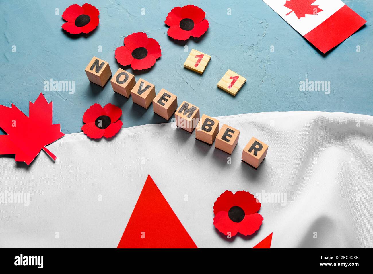Poppy flowers with flags of Canada and text 11 NOVEMBER on blue ...