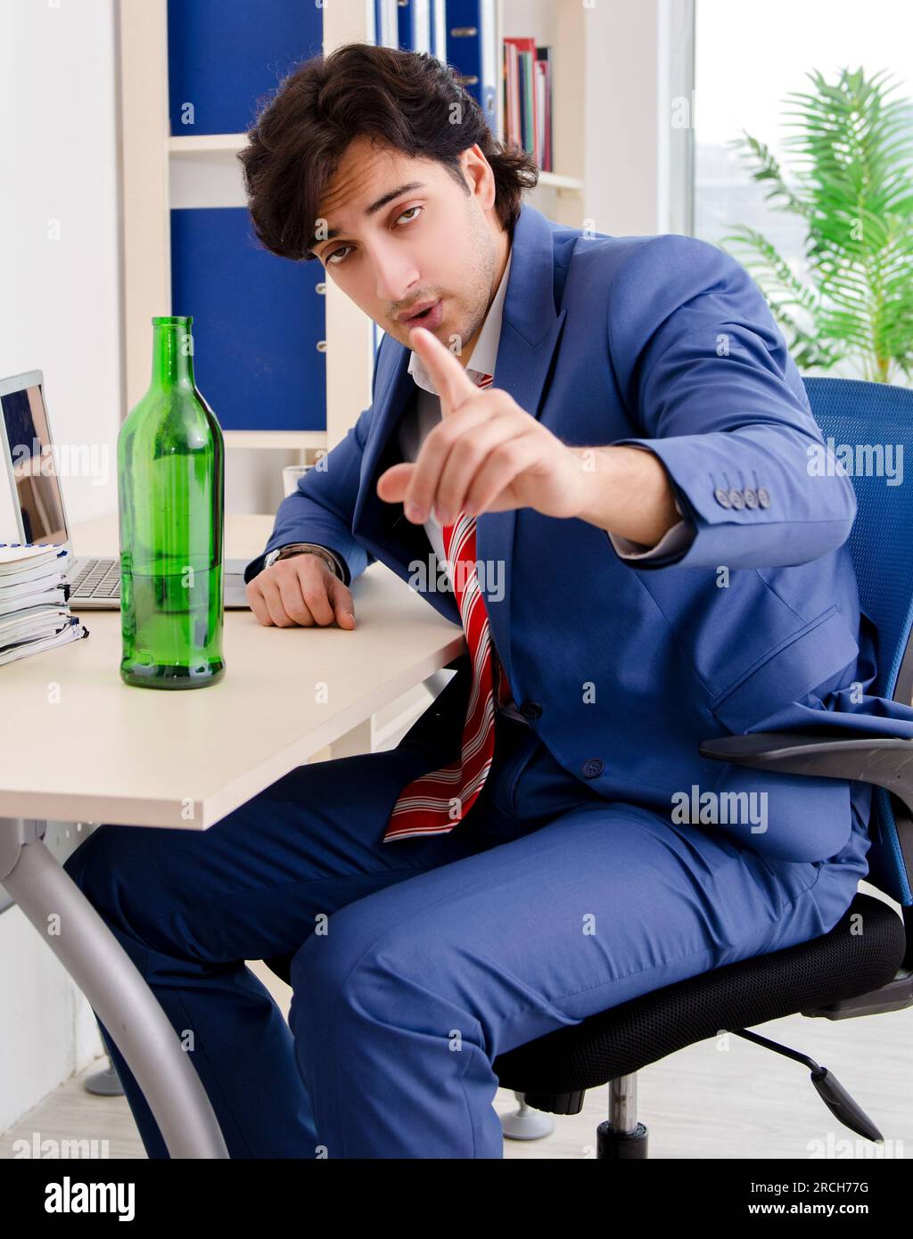 The young businessman employee drinking in the office Stock Photo - Alamy