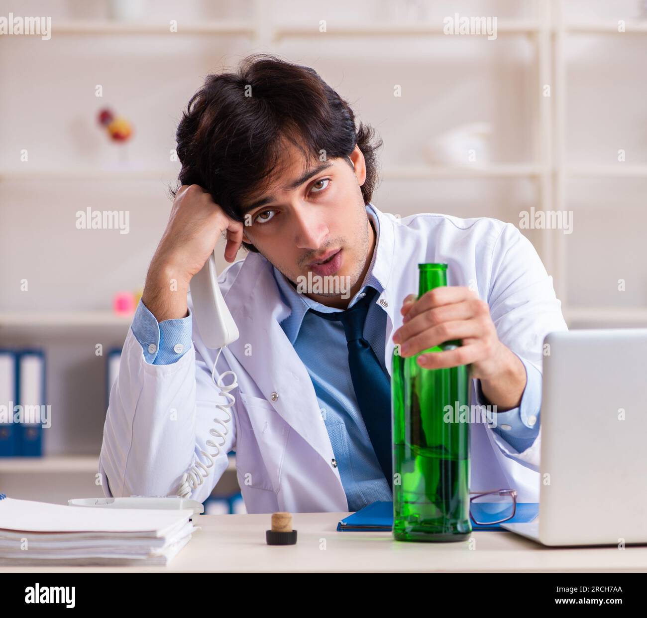 The young male doctor drinking in the office Stock Photo - Alamy
