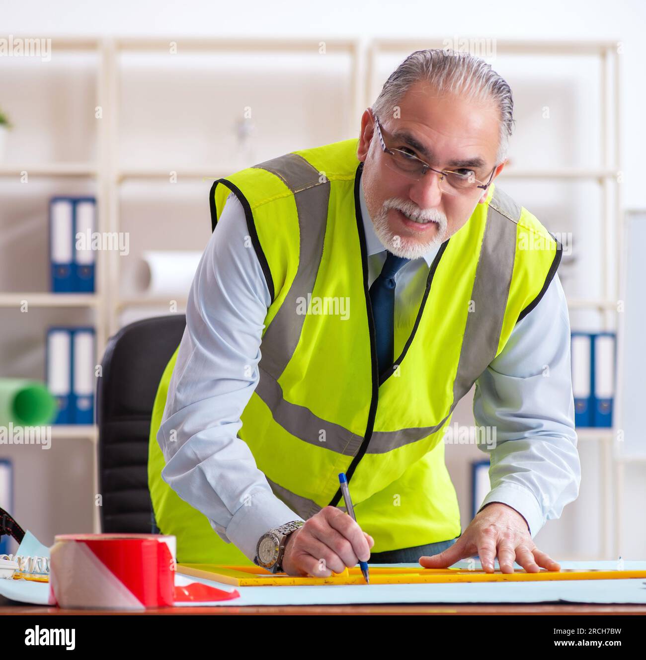 The aged construction engineer working in the office Stock Photo - Alamy