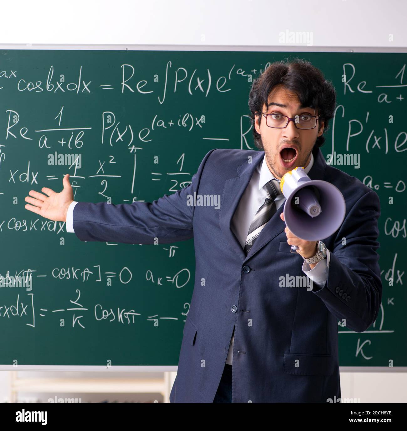 The young male math teacher in classroom Stock Photo - Alamy