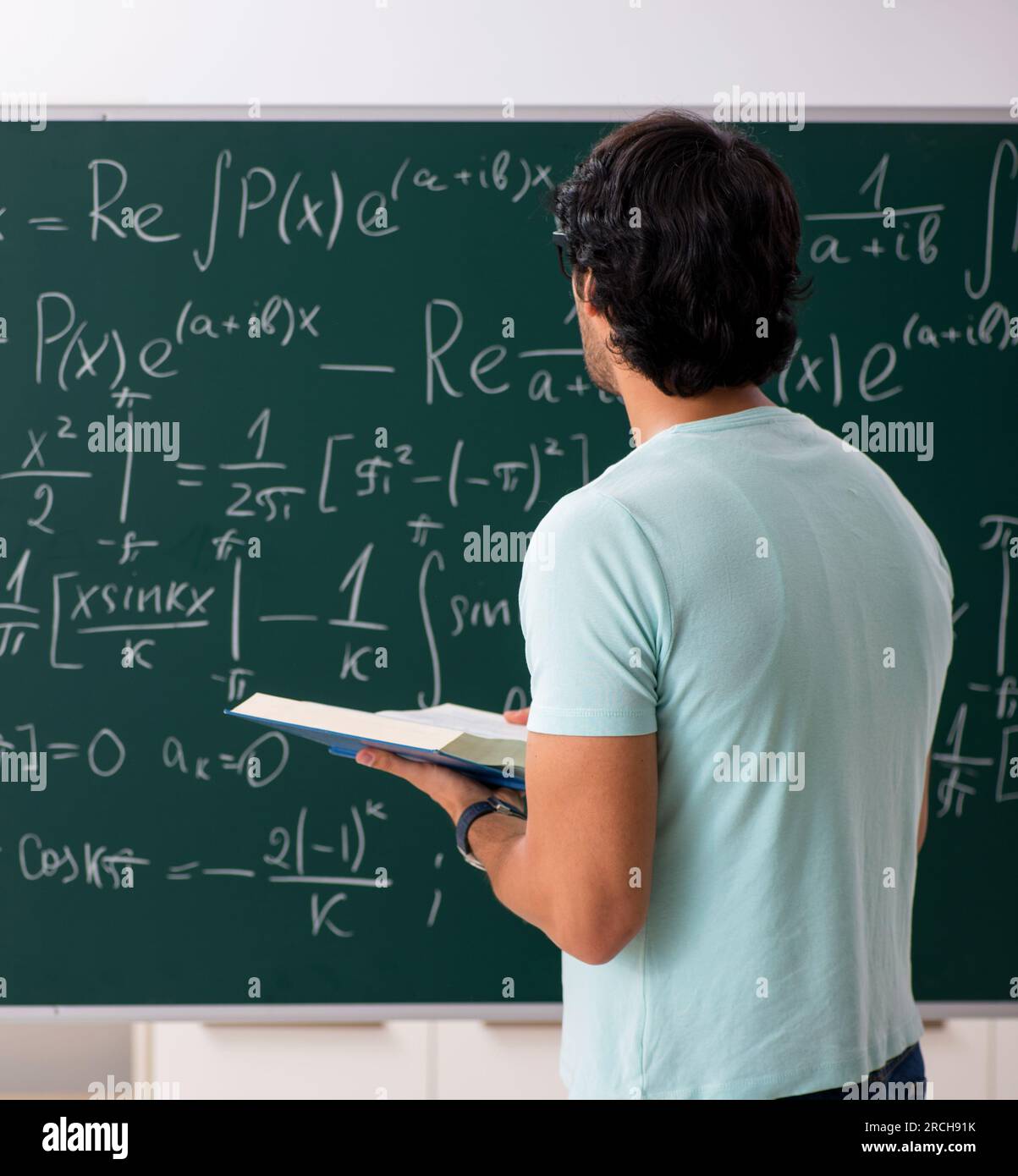 The young male student mathematician in front of chalkboard Stock Photo ...
