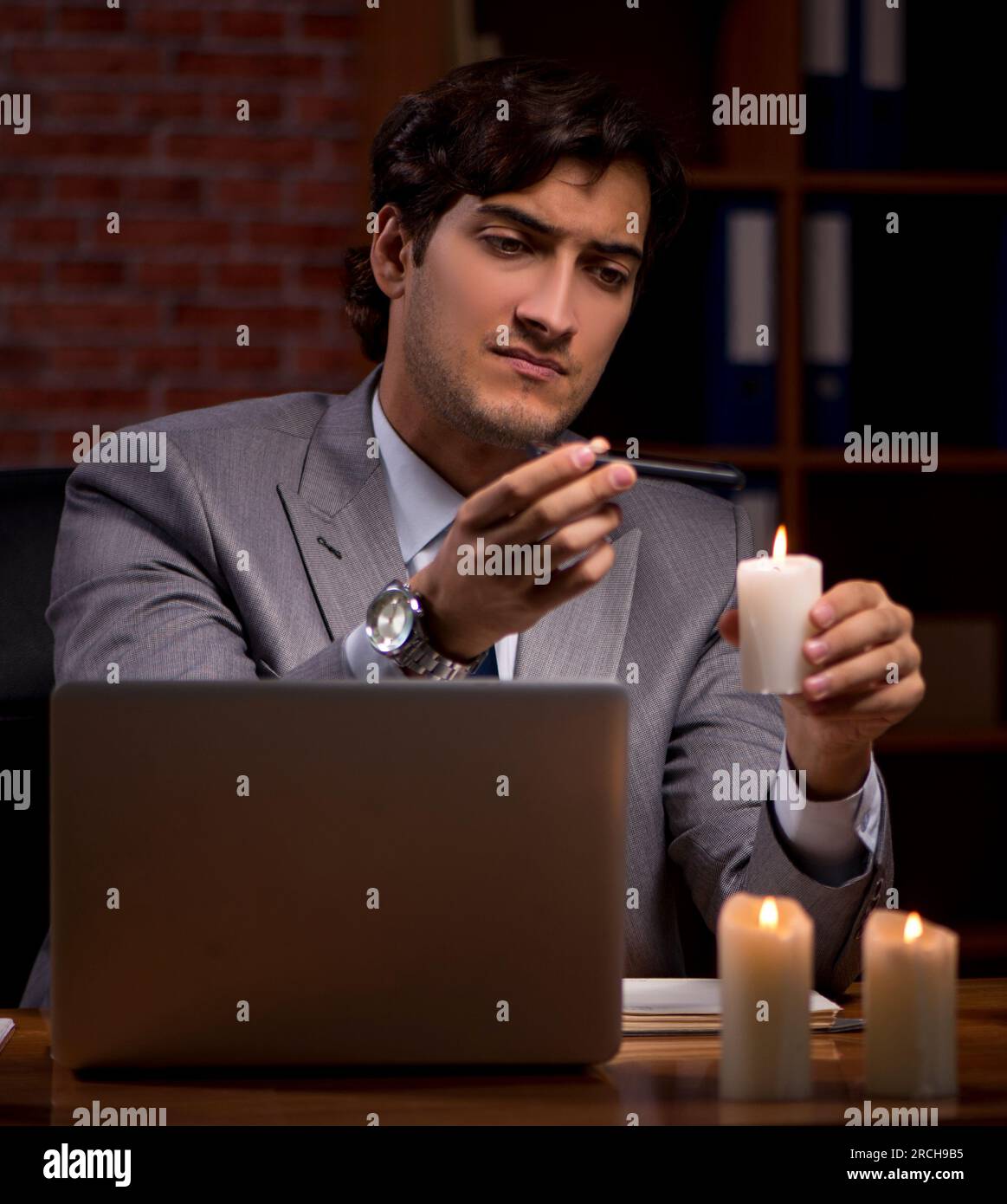 The businessman working late in office with candle light Stock Photo ...