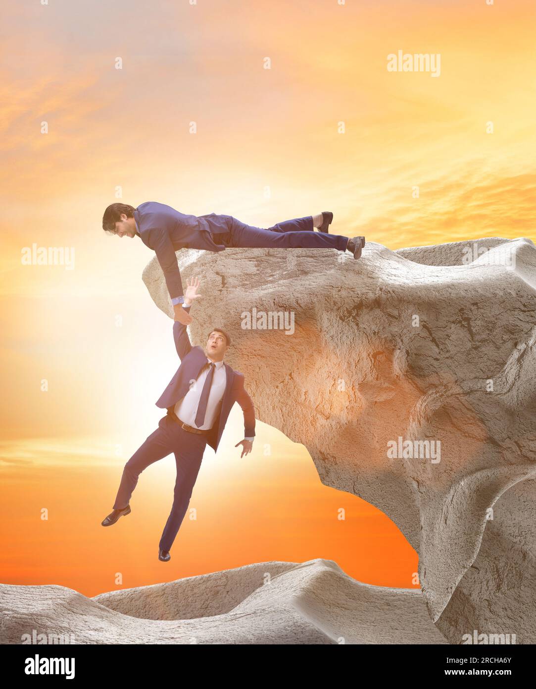 The businessman offering helping hand to falling colleague Stock Photo ...