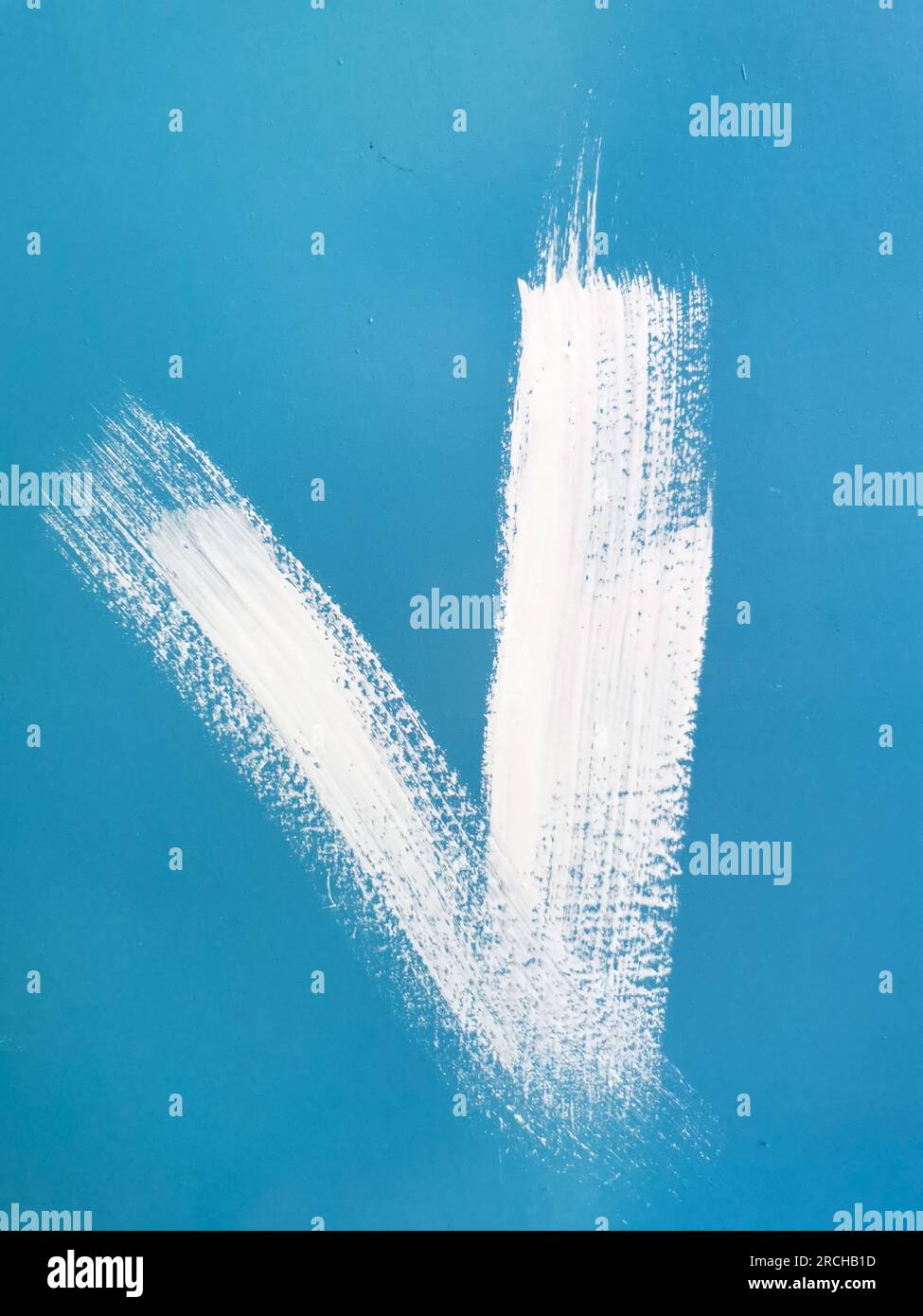 White paint V on blue background Stock Photo - Alamy