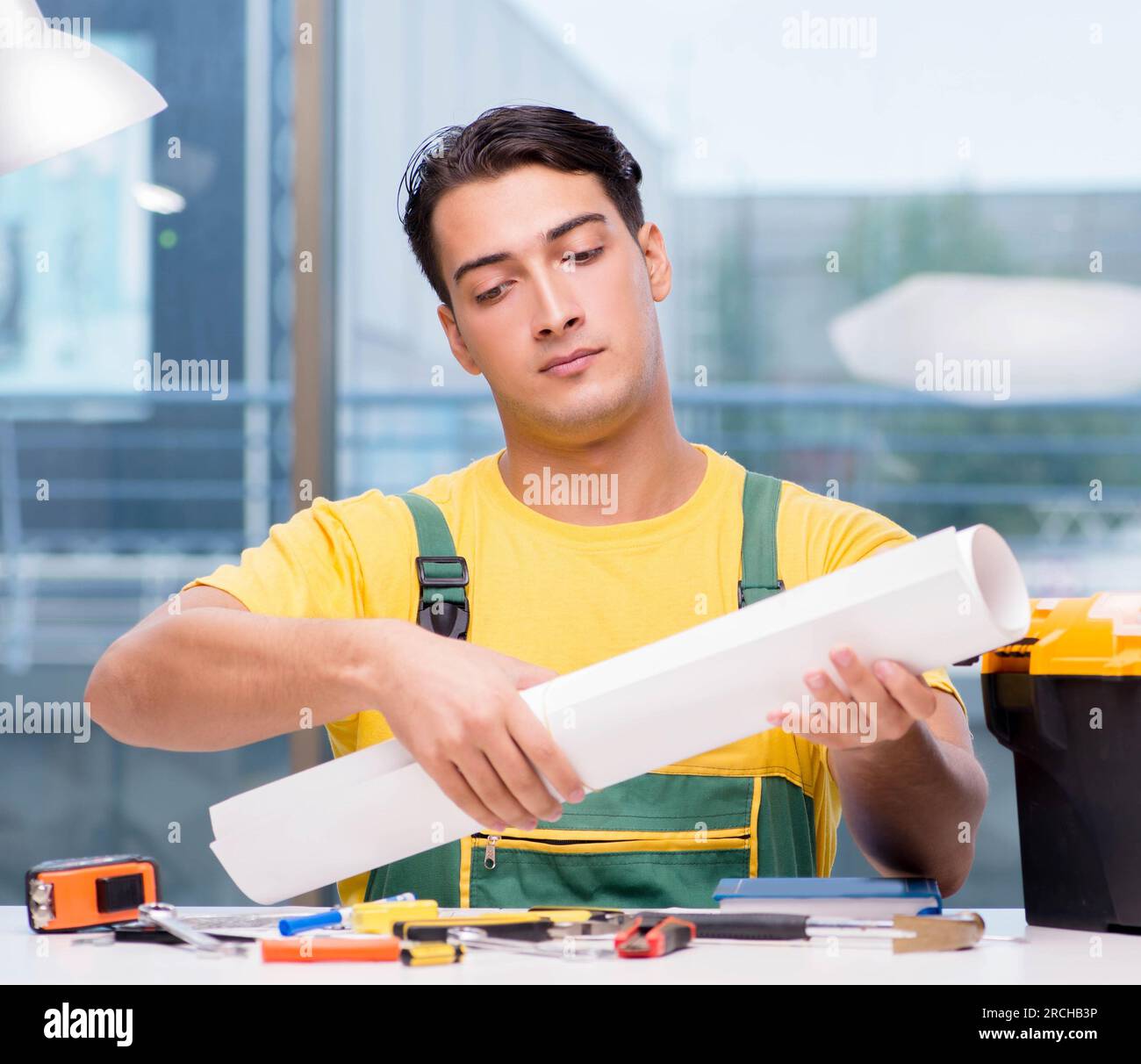 The construction worker sitting at the desk Stock Photo - Alamy