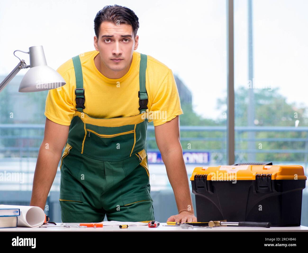 The construction worker sitting at the desk Stock Photo - Alamy